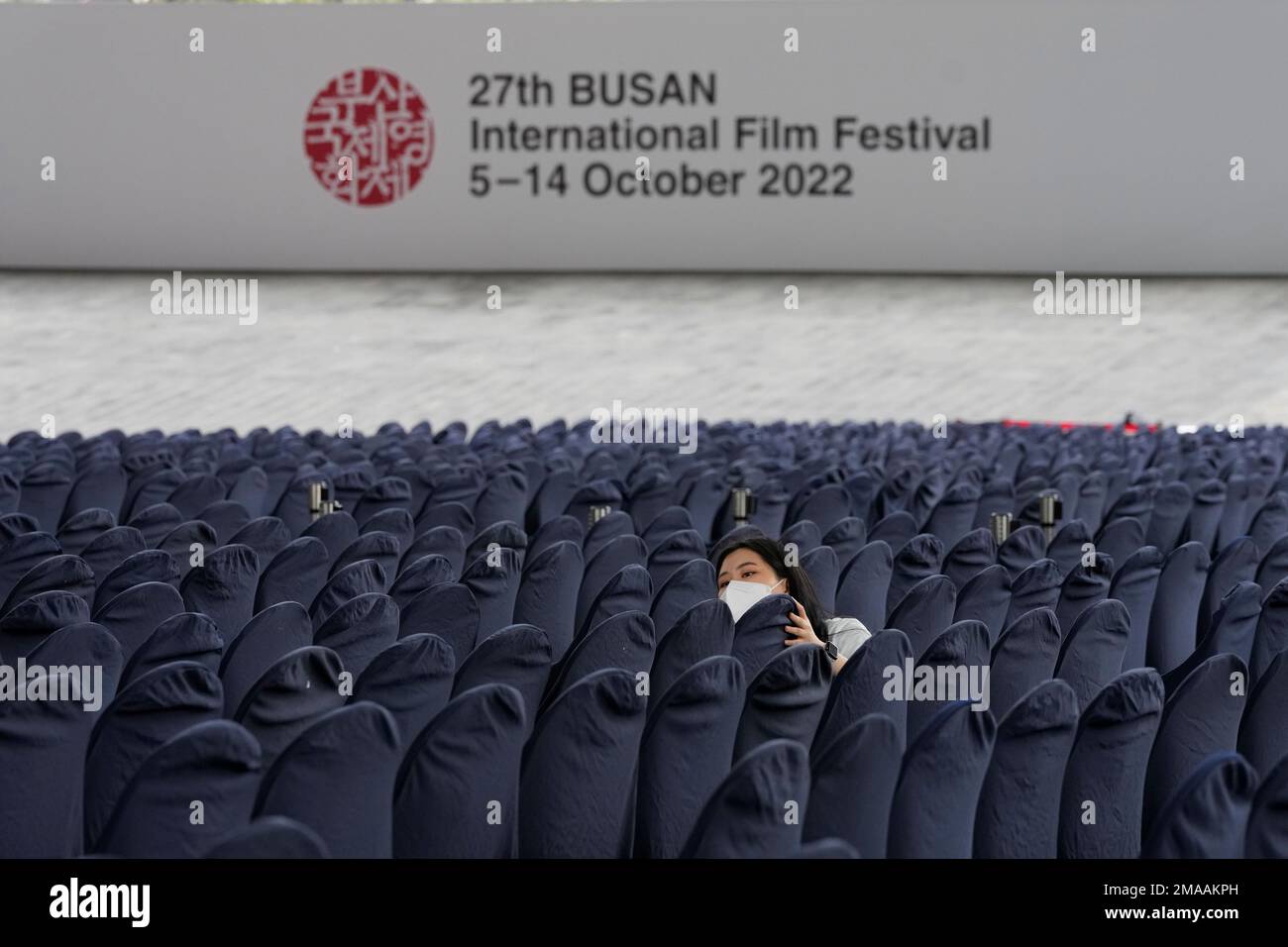 A volunteer arranges chairs for the opening ceremony of the 27th Busan International Film ...