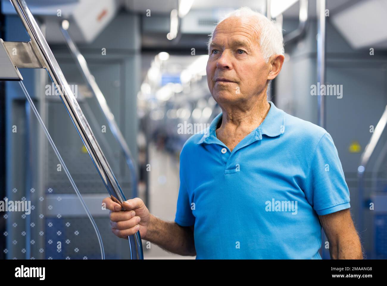 Senior man standing inside subway train Stock Photo - Alamy
