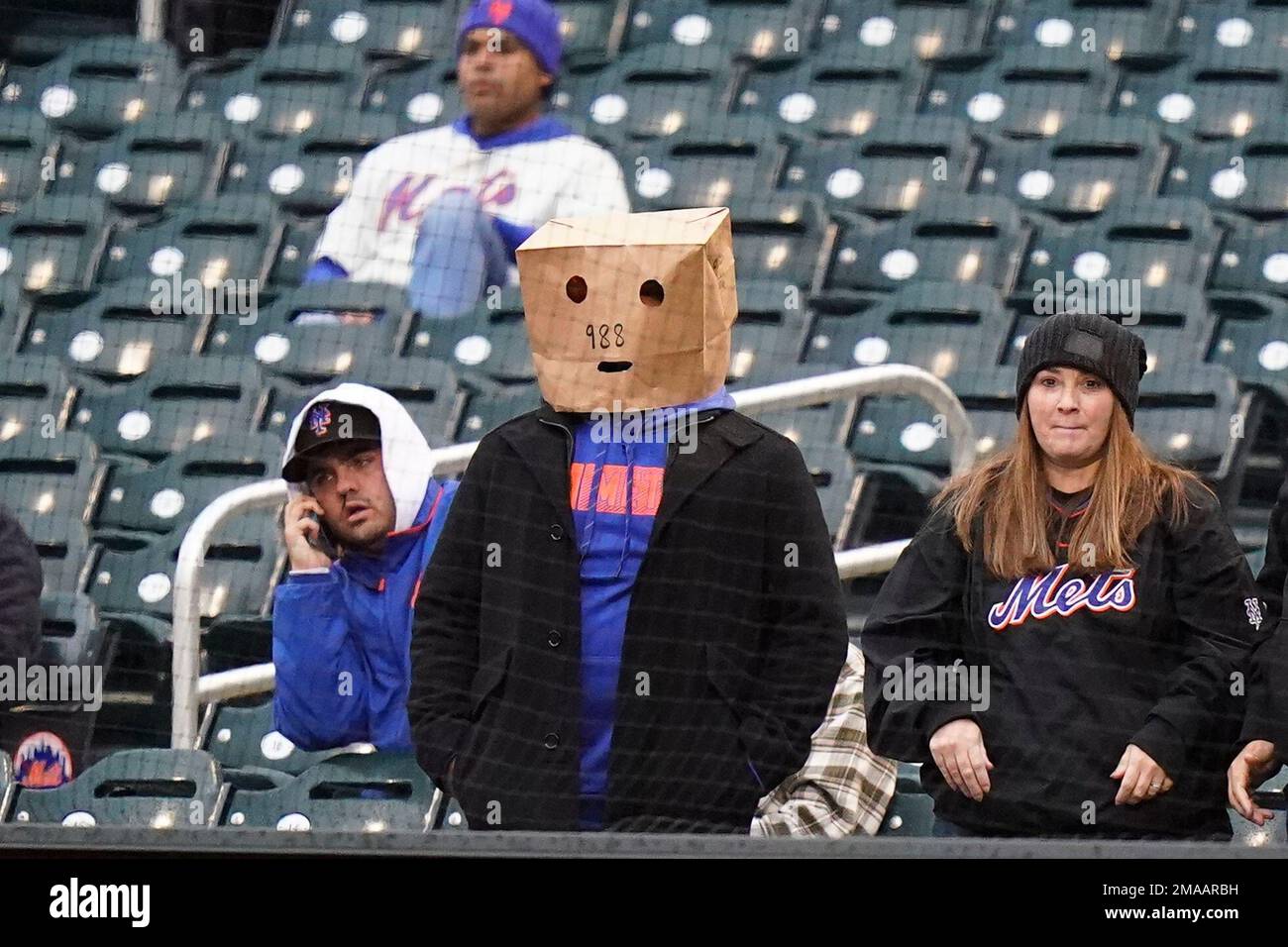 New York Mets fans, one wearing a paper bag over their head, watch as ...