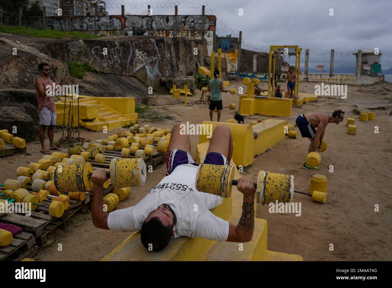 Men exercise on Praia do Diabo beach in Rio de Janeiro, Brazil, Tuesday ...