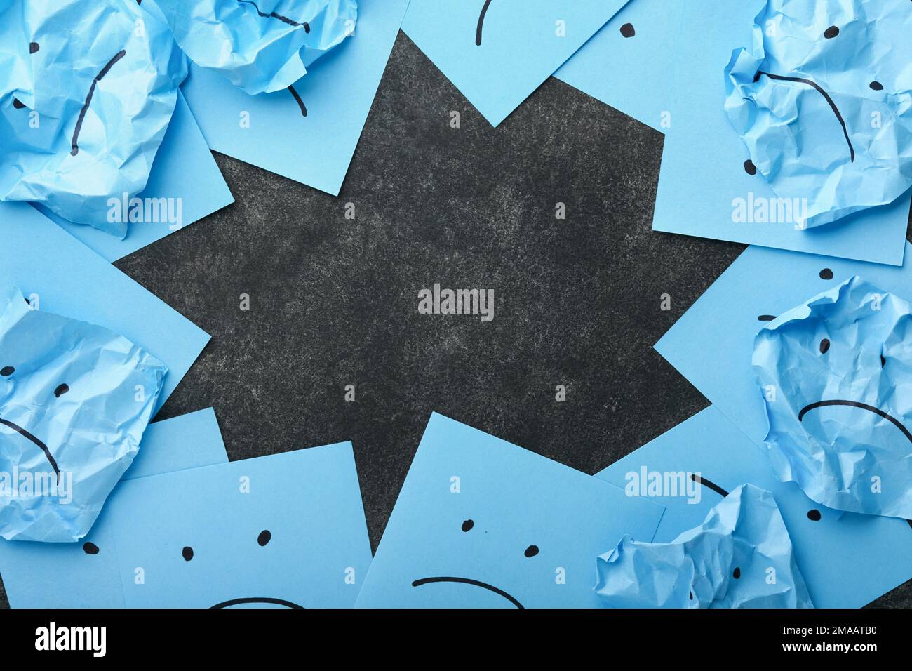 Blue crumpled sticky notes blank with drawing sad face on black ...