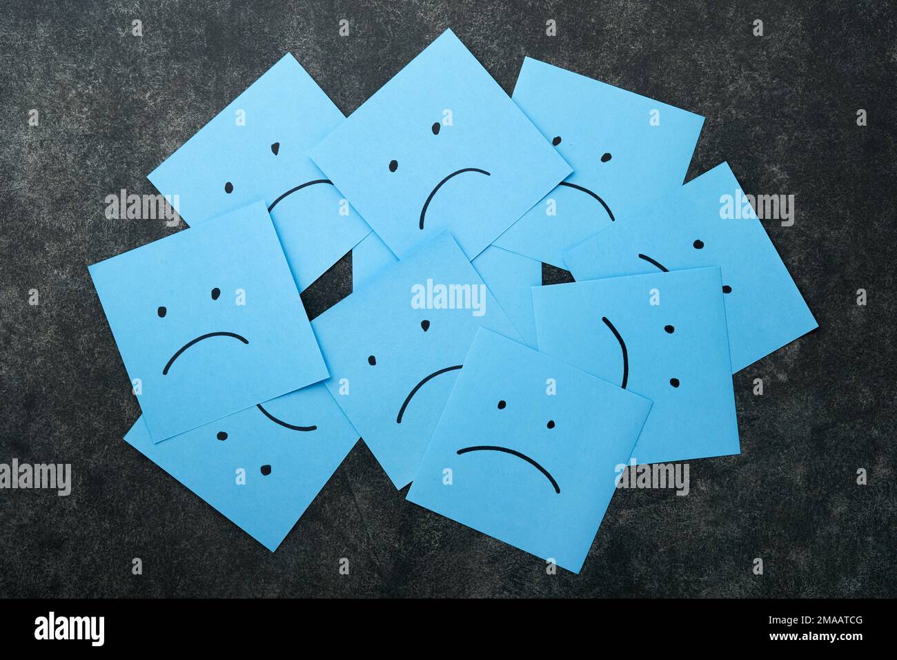 Blue sticky notes blank with drawing sad face on black background with ...