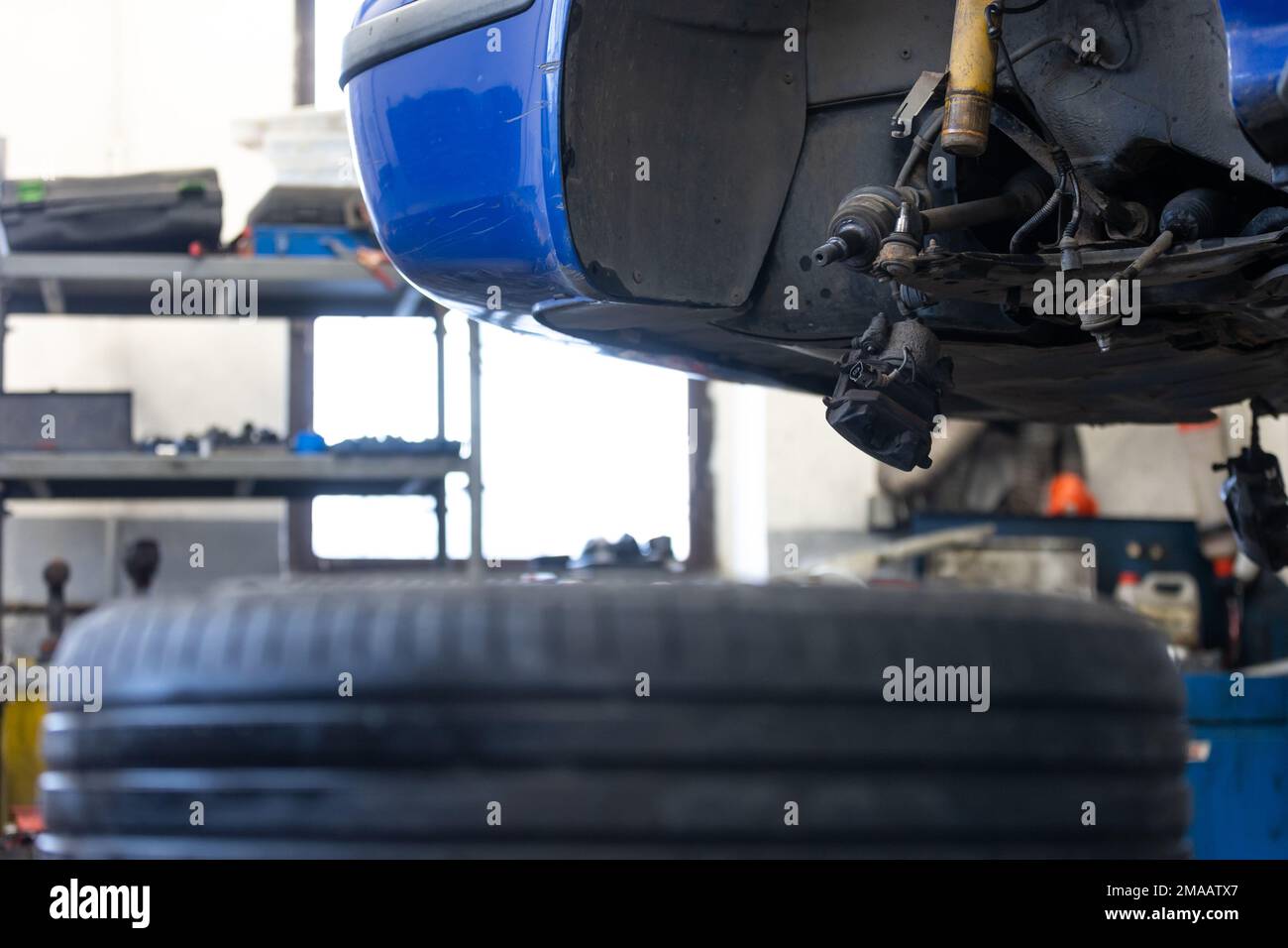 Car service center concept, vehicle raised on lift at maintenance ...