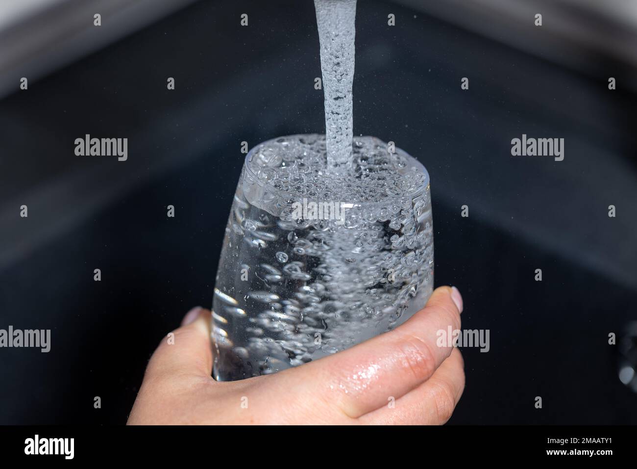 Woman pouring fresh cold water from the sink, drink concept Stock Photo ...