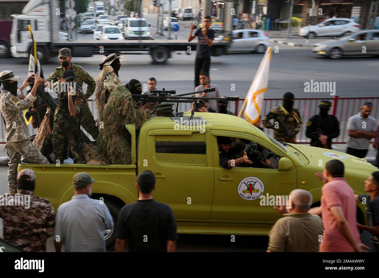 Residents watch Masked members of the Palestinian Al-Quds Brigades, the ...