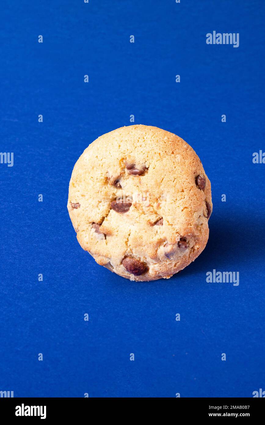 Photo of a homemade chocolate chip cookie isolated on a blue background ...