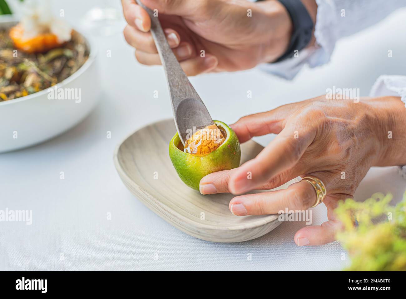 a person tastes a haute cuisine dish of lemon, foie gras and honey with ...