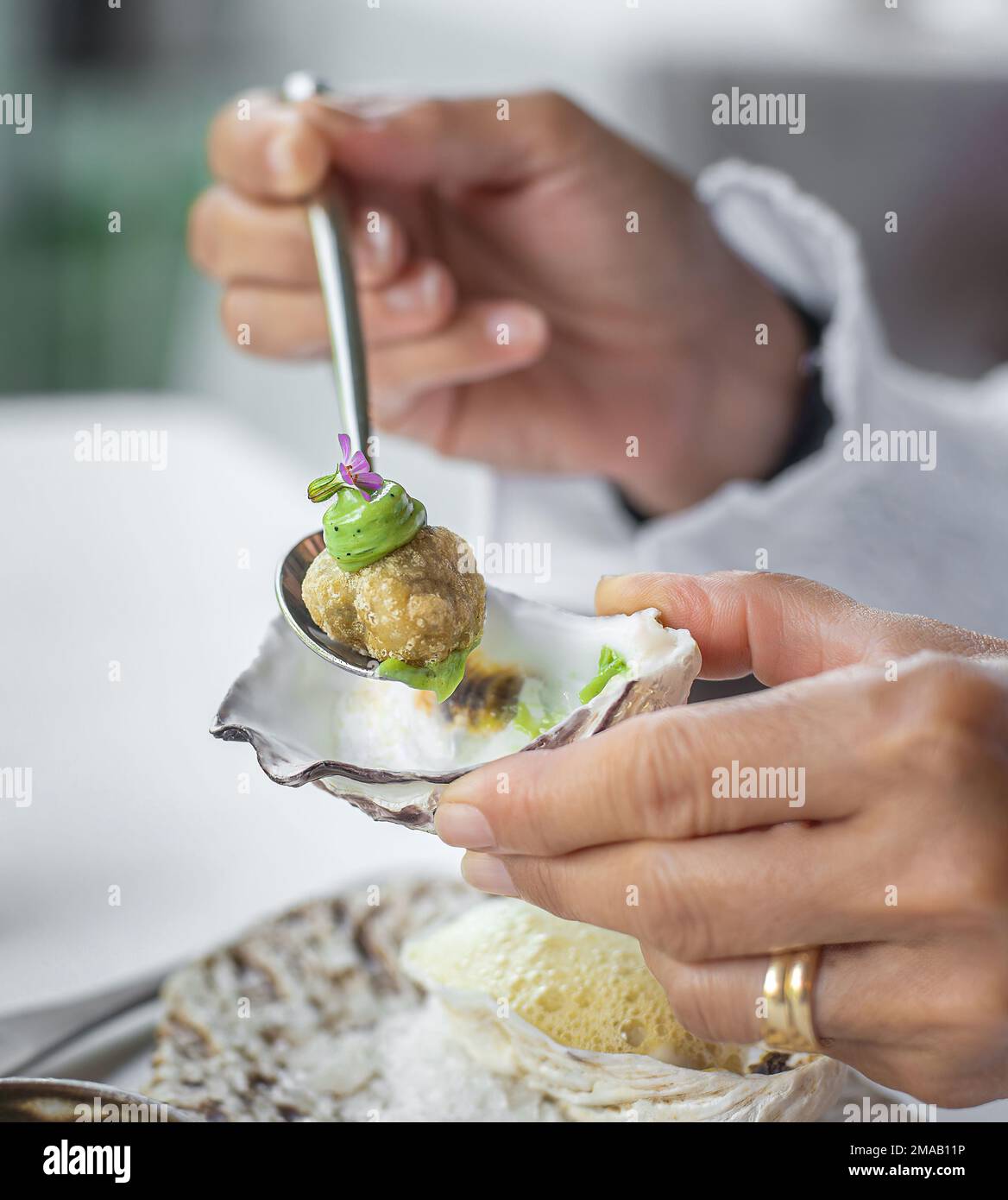 detail of a person tasting a gourmet recipe based on oyster tempura ...