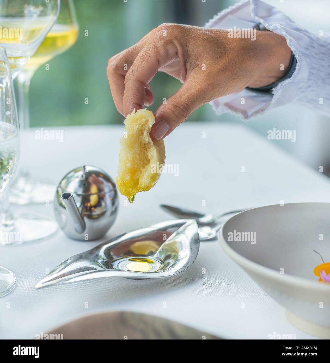 detail of hands spreading a loaf of chinese style bread in olive oil ...