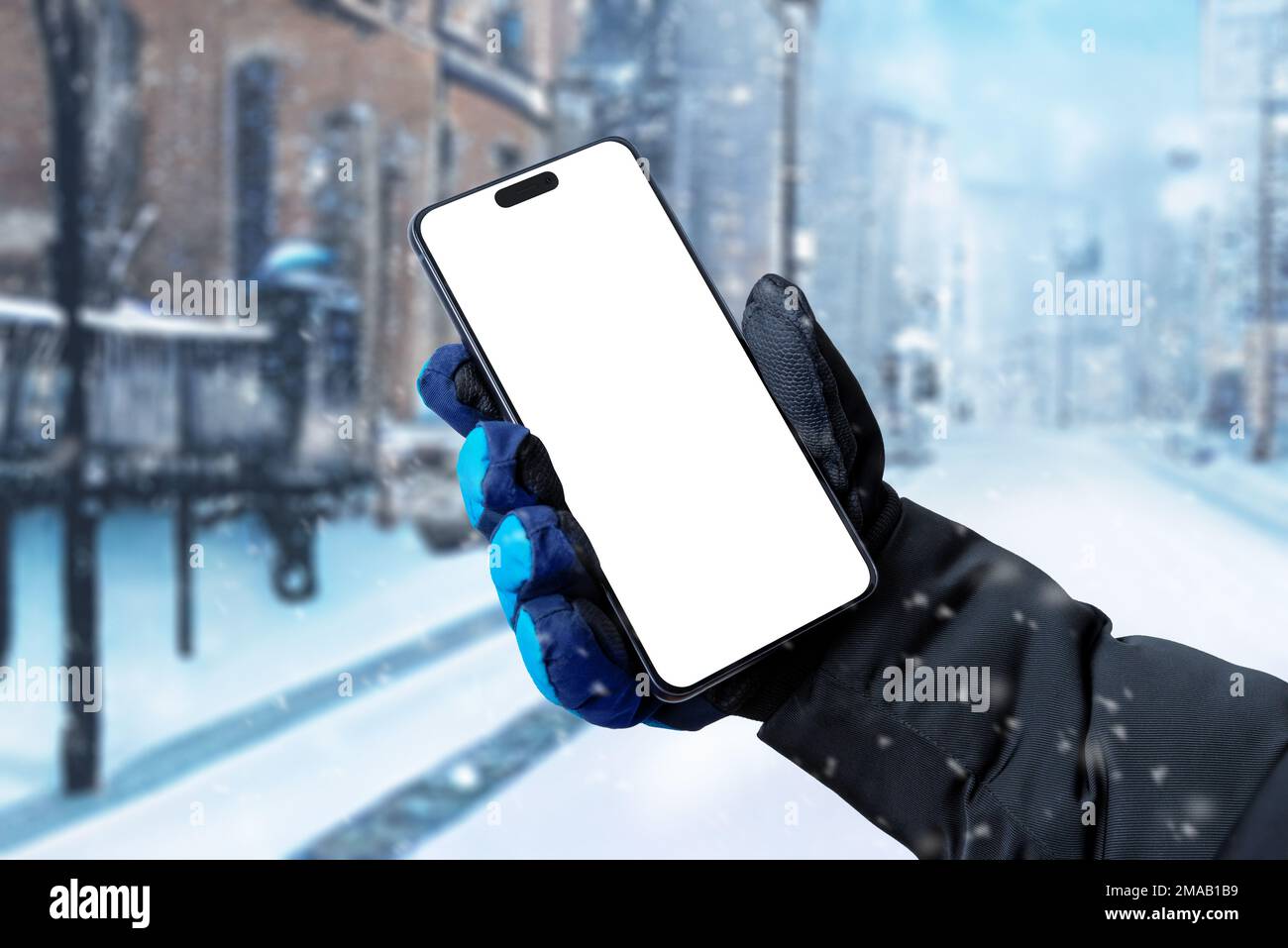 Using a mobile phone on the street while it is snowing. Isolated ...