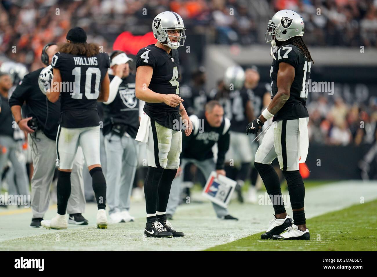 Las Vegas Raiders quarterback Derek Carr (4), middle, talks to wide receiver Davante Adams (17 ...