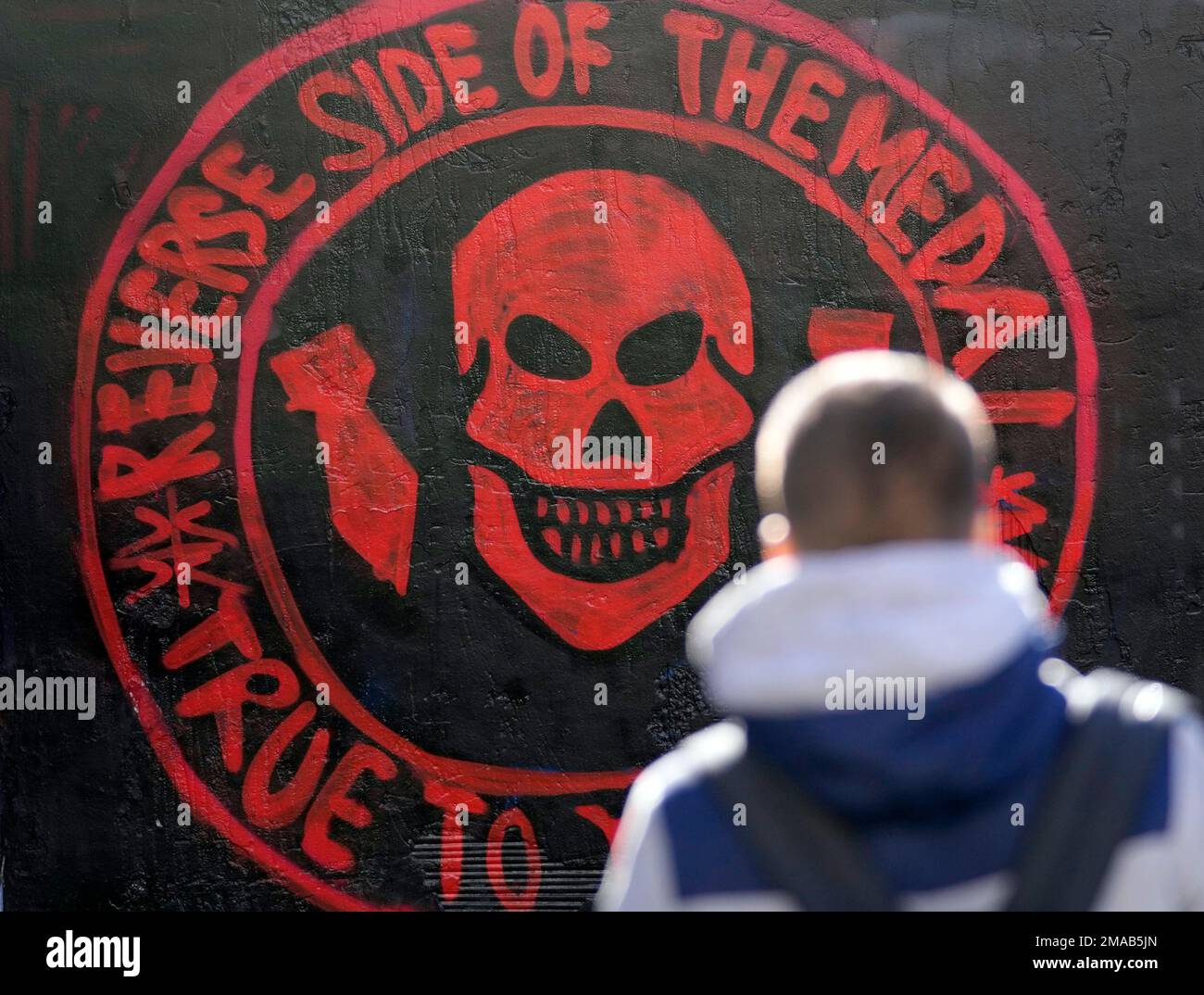A boy walks by a repainted mural depicting the logo of Russia's Wagner ...