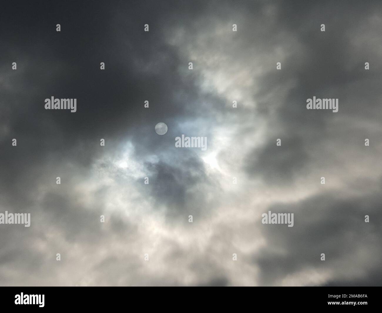 The full moon in the gray cloudy sky Stock Photo - Alamy