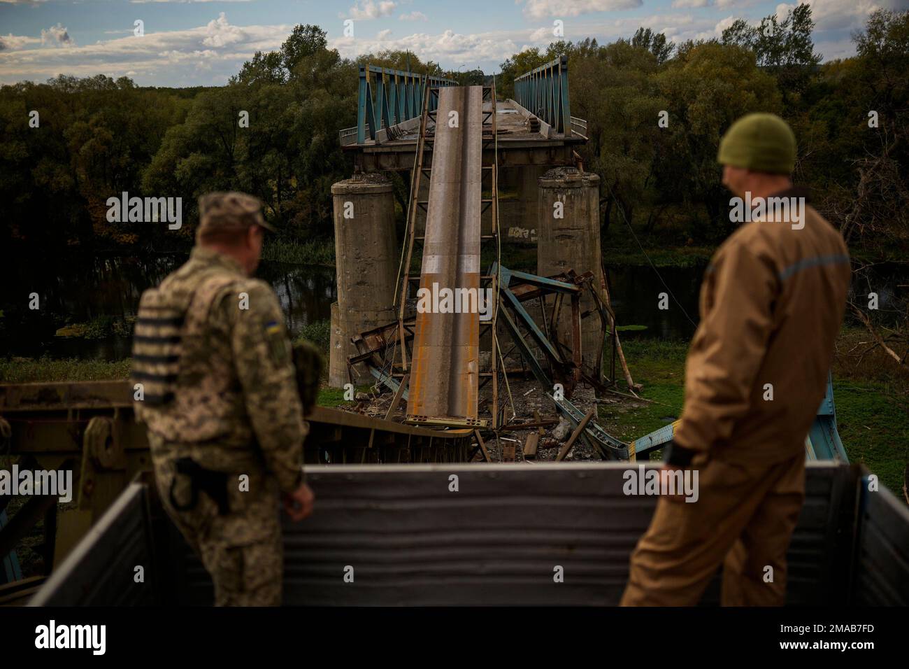 Ukrainian soldiers remove metal structure pieces as they work on a ...