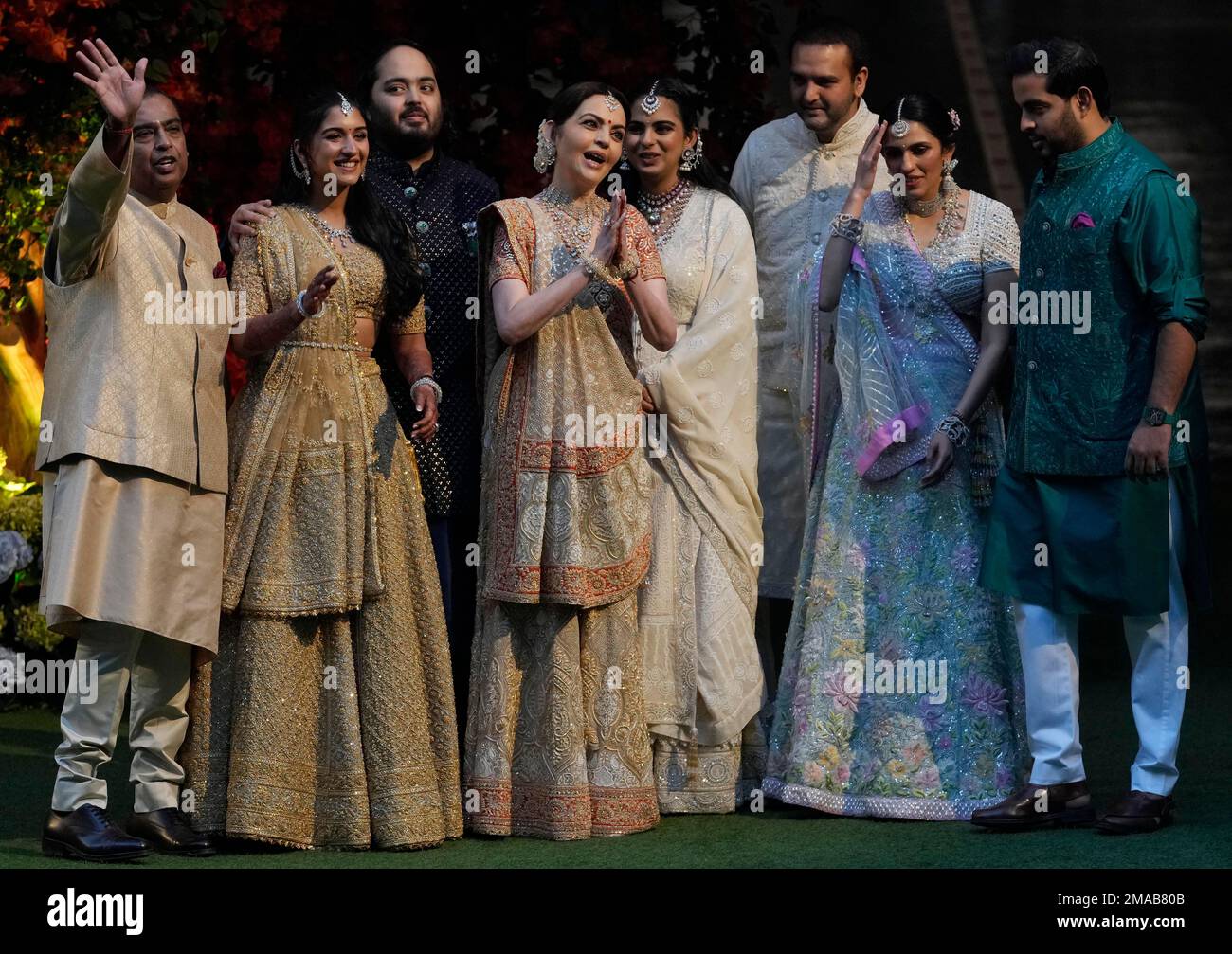 Chairman of Reliance Industries Limited Mukesh Ambani, left, waves to ...
