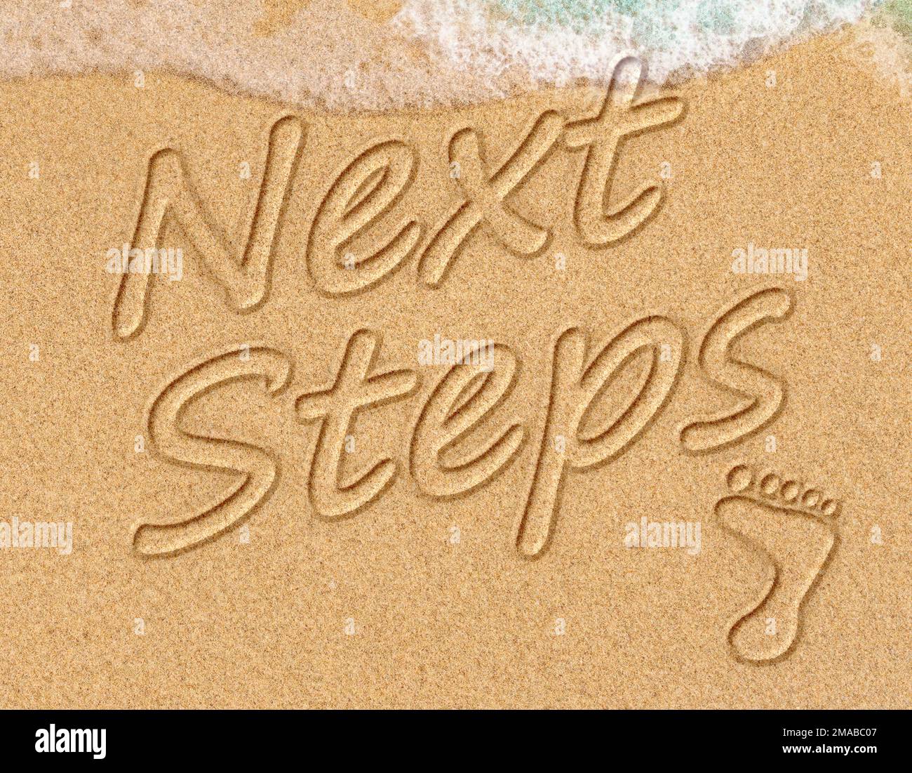 Next Steps on the sand on the beach with the sea washing up the shore ...