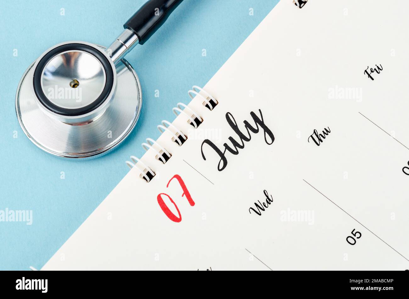 July 2023 deskcalendar and medical stethoscope medical on blue ...