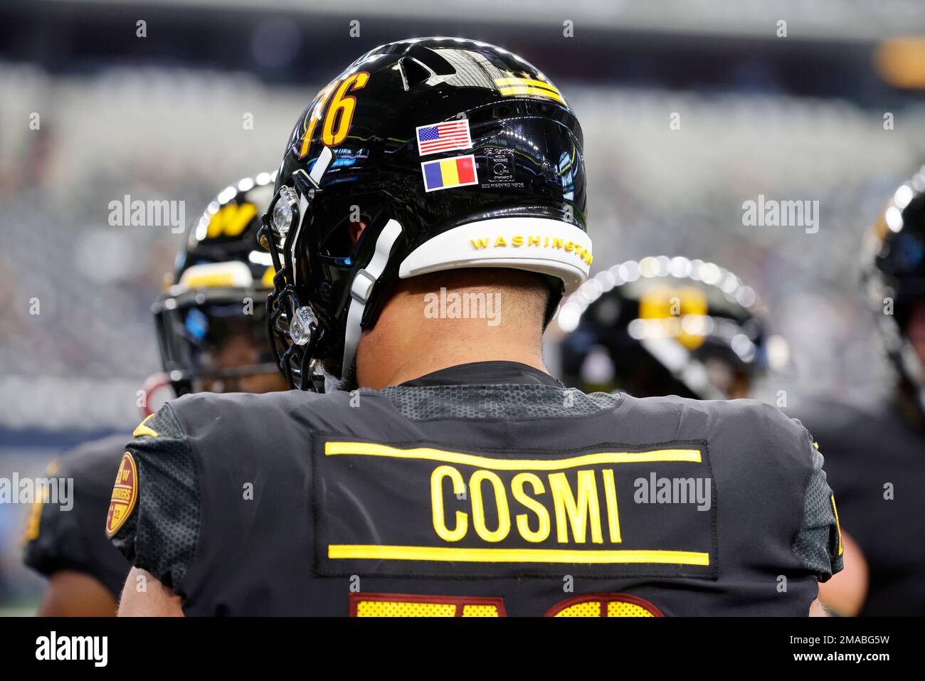 Washington Commanders offensive tackle Sam Cosmi (76) displays a US and ...