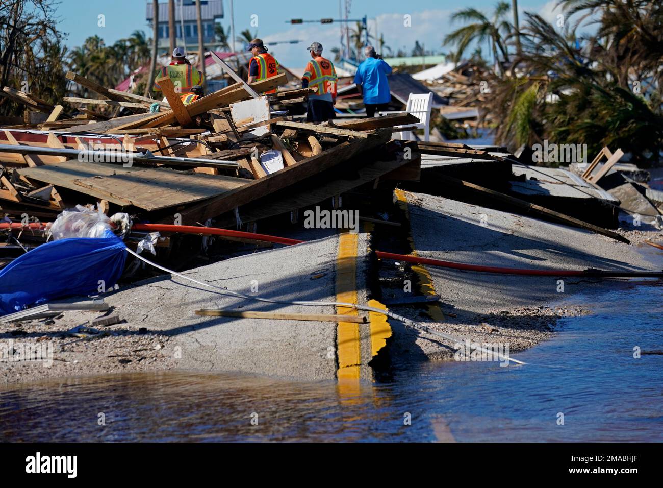 Responders from the de Moya Group survey damage to the bridge leading ...