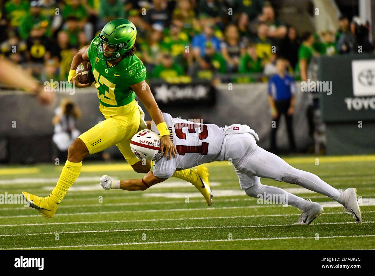 Oregon quarterback Ty Thompson (13) tries to elude the tackle of ...