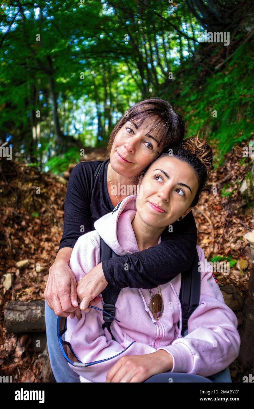 Cute lovely lovely mature lady mom woman hugging her brunette girl ...