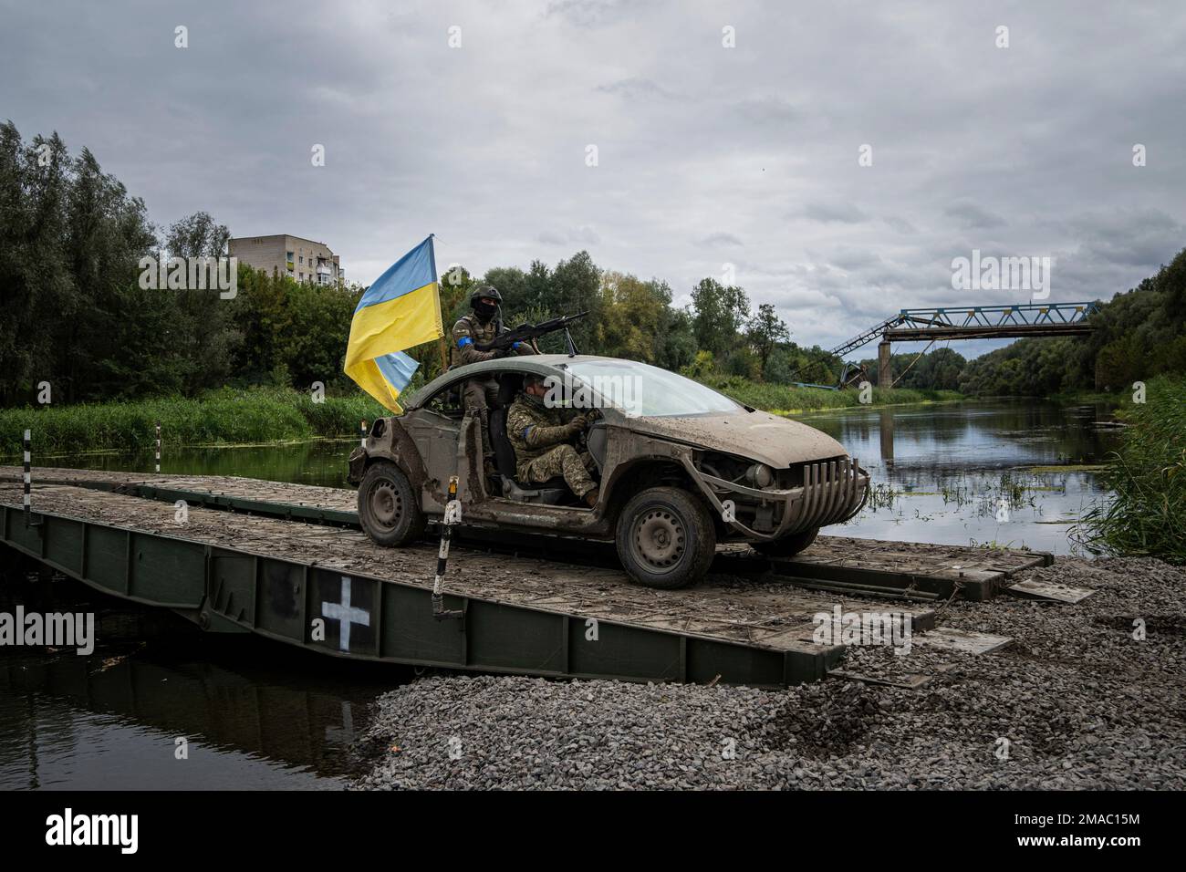 Ukrainian paratroopers drive with a Ukrainian flag on a pontoon bridge ...