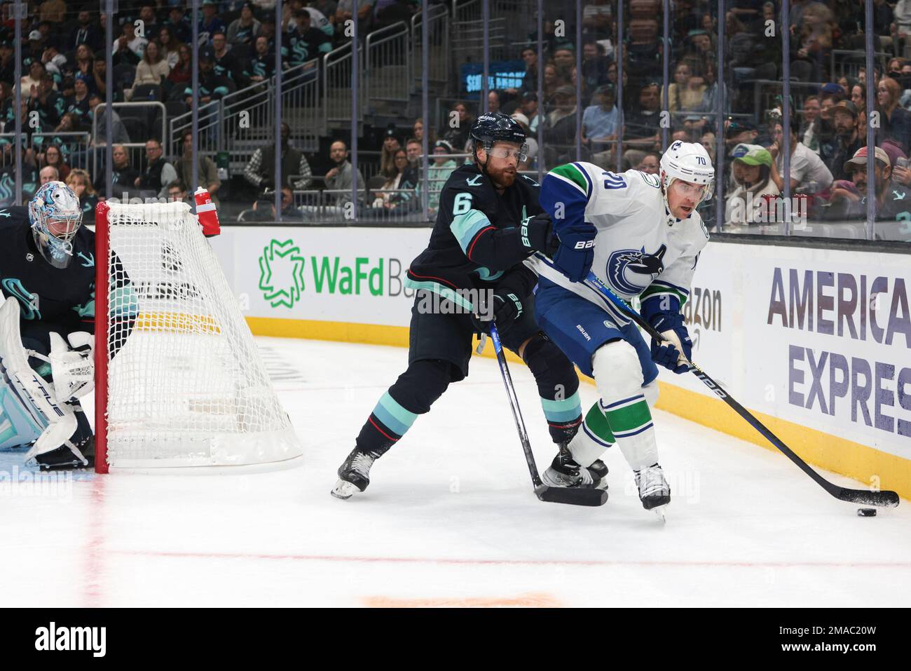 Vancouver Canucks forward Tanner Pearson (70) is guarded by Seattle Kraken defenseman Adam ...