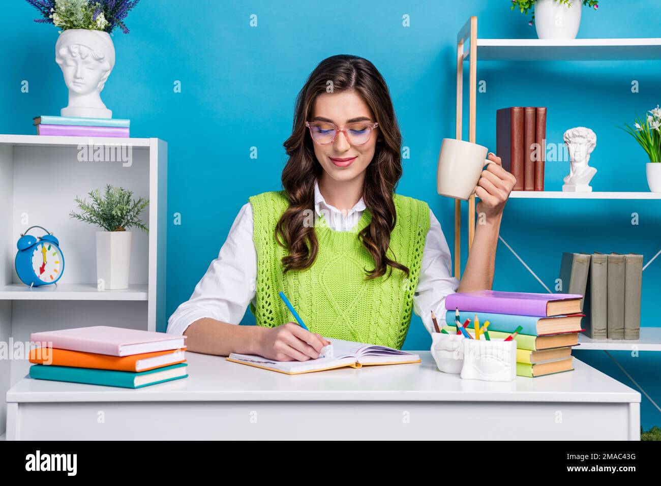 Portrait of attractive intelligent girl arm hold tea mug pen write take ...