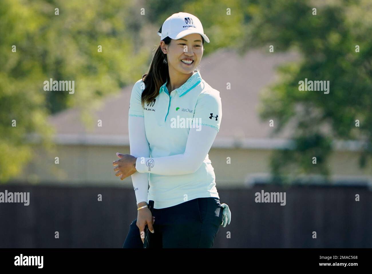 Xiyu Janet Lin, of China, smiles as she waits to putt on the the 18th ...