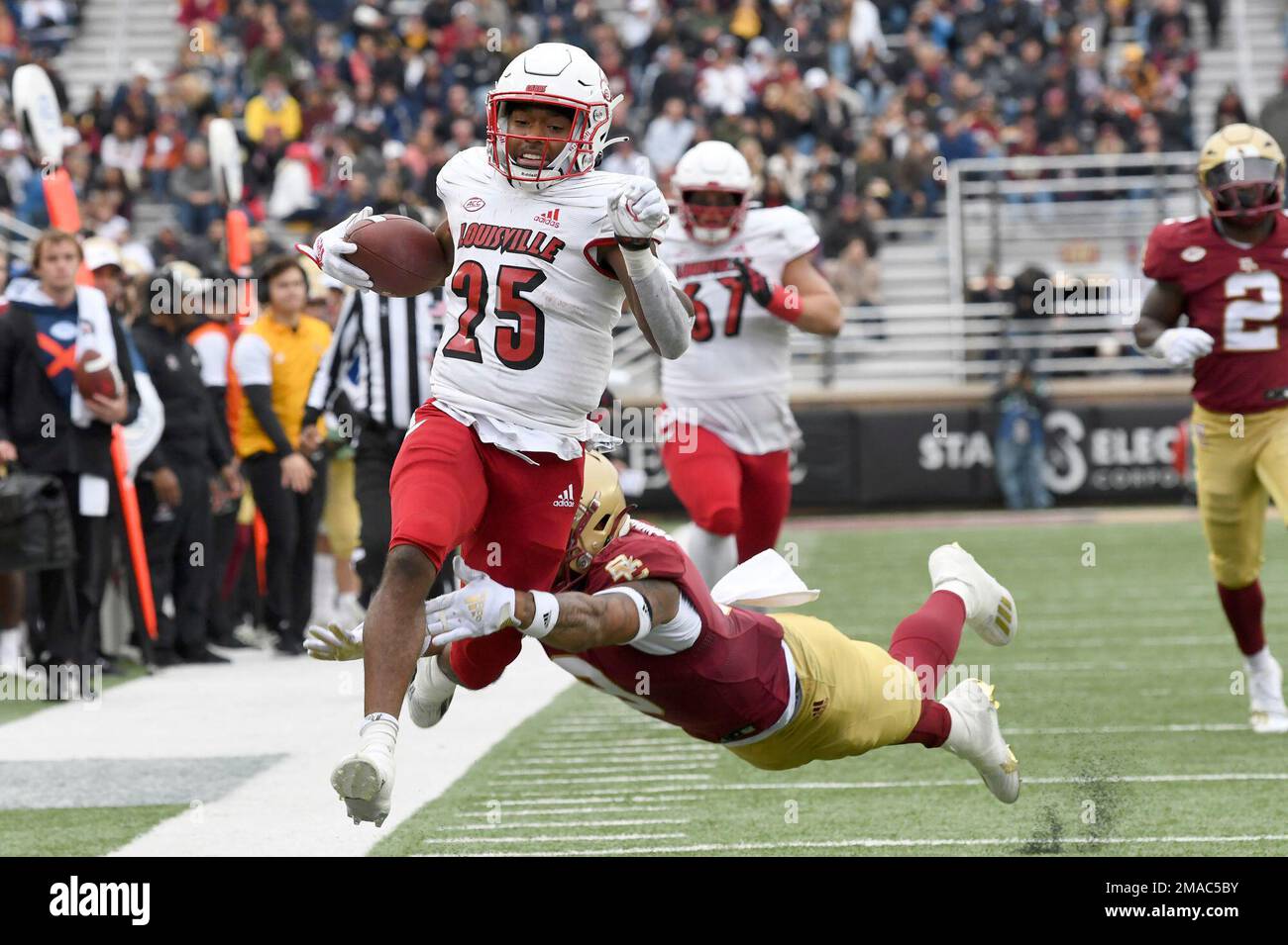 Louisville running back Jawhar Jordan eludes the grasp of Boston College's Jaiden Woodbey as he ...