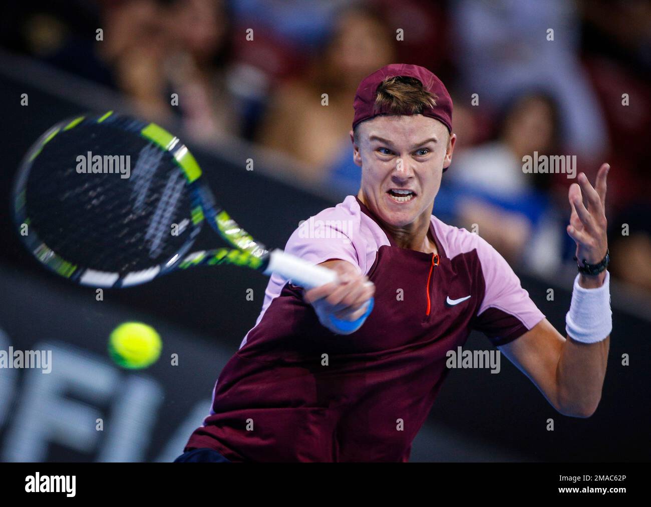 Holger Rune of Denmark returns a shot during his match against Italy's Jannik Sinner at the semi ...
