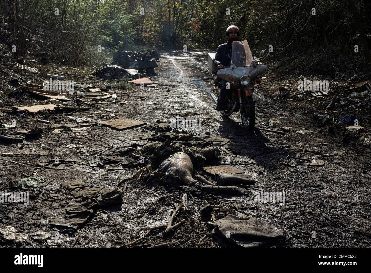 EDS NOTE: GRAPHIC CONTENT - A local man rides his motorbike past the ...