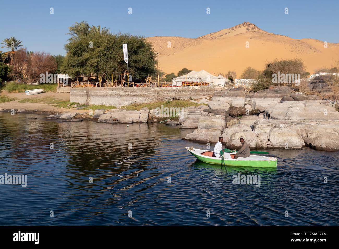ASWAN, EGYPT - 29 Dec 2022. Two Nubian man paddling in a wooden boat ...