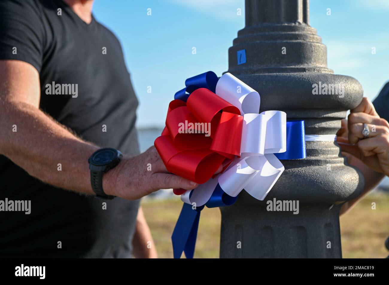 Volunteers place a ribbon on a lamp post during the Second Annual ...
