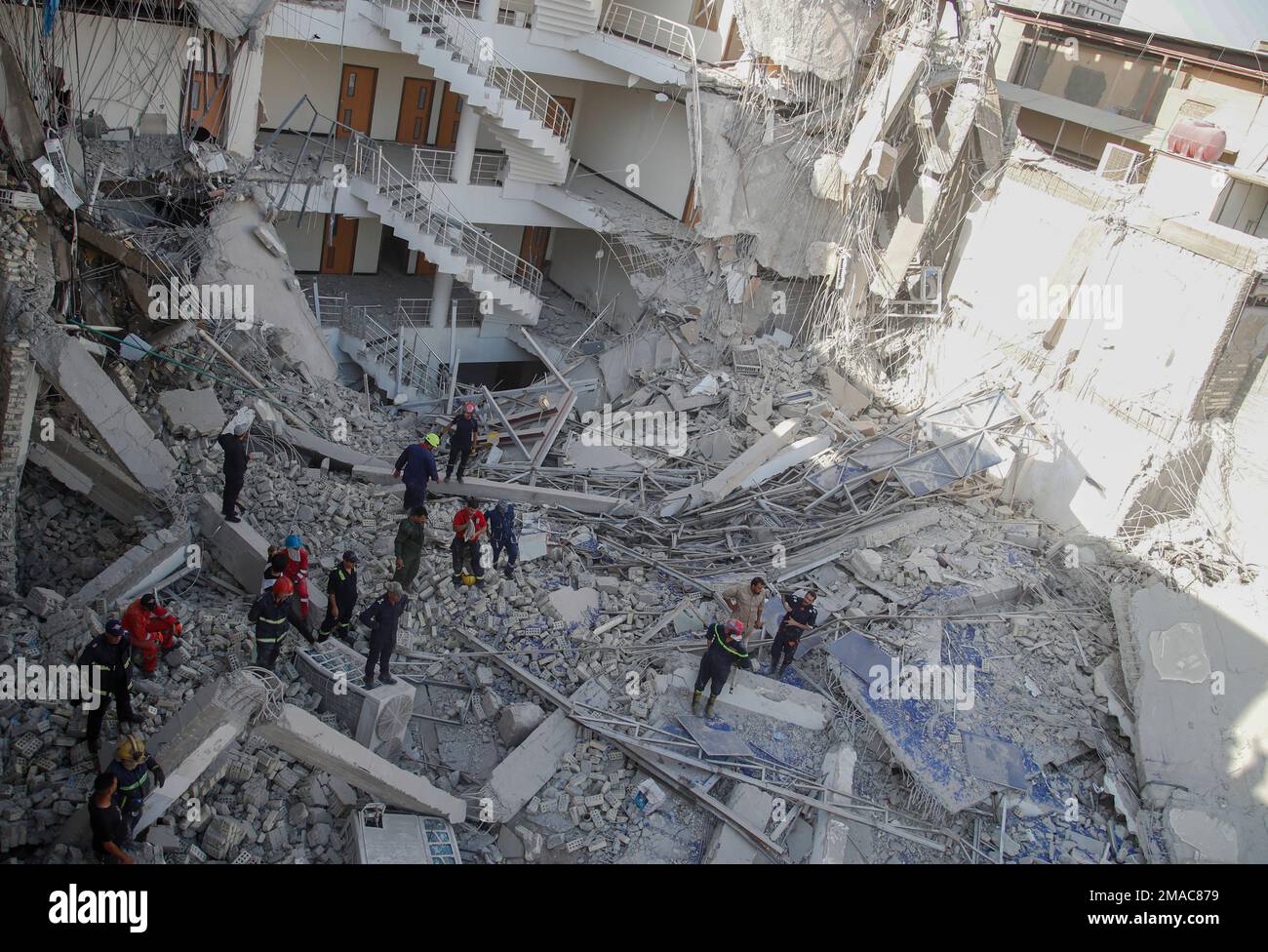 Iraqi emergency and rescue personnel search for survivors in the rubble ...
