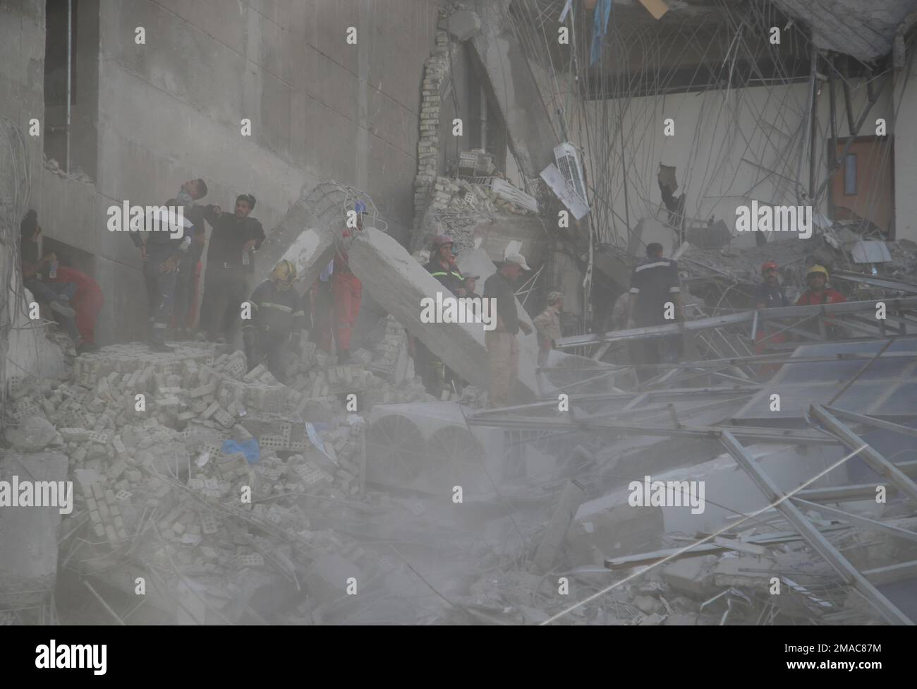 Iraqi emergency and rescue personnel search for survivors in the rubble ...