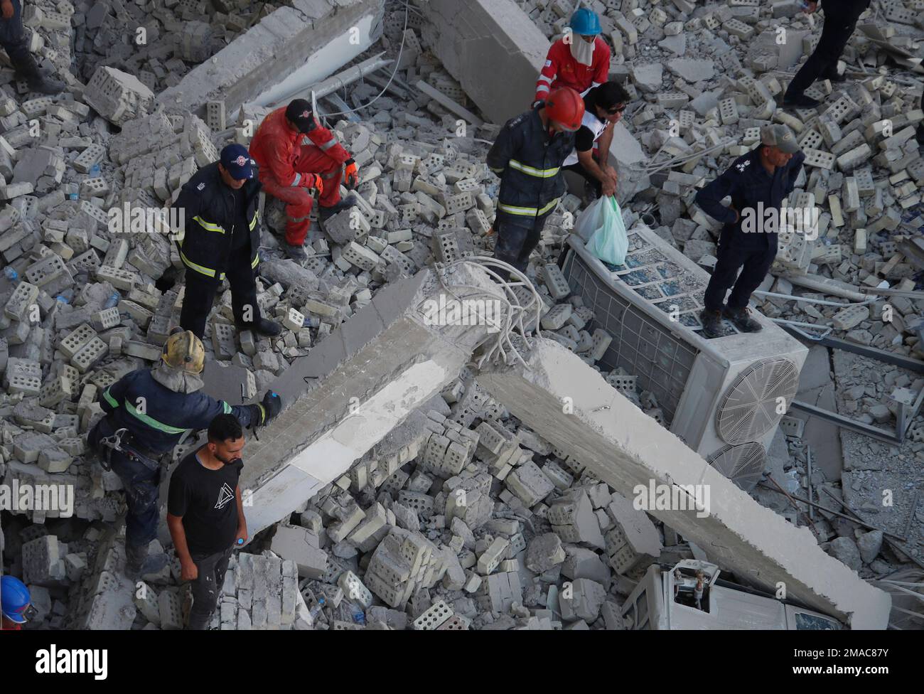 Iraqi emergency and rescue personnel search for survivors in the rubble ...