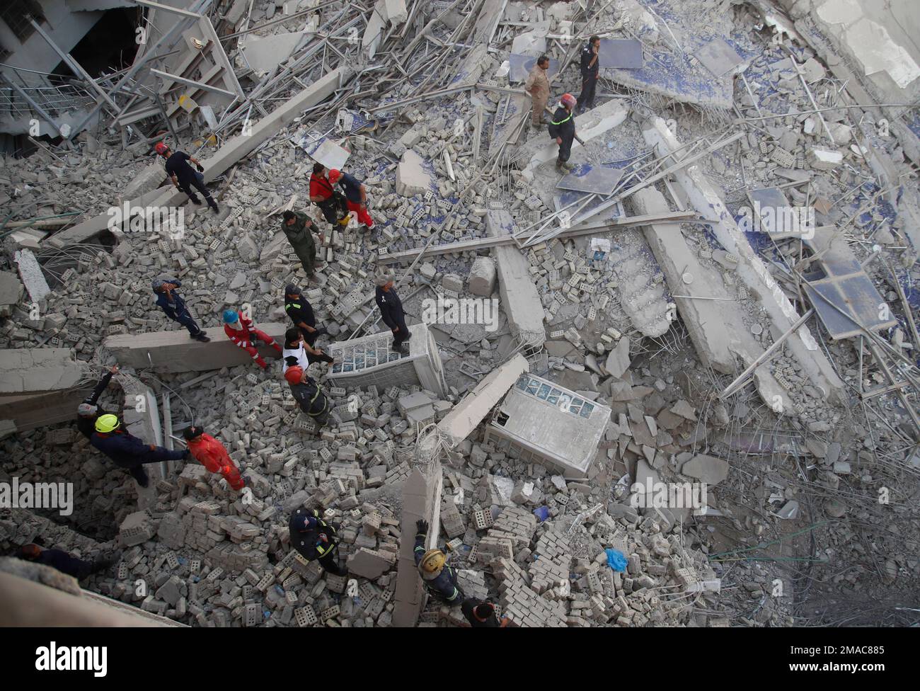 Iraqi emergency and rescue personnel search for survivors in the rubble ...