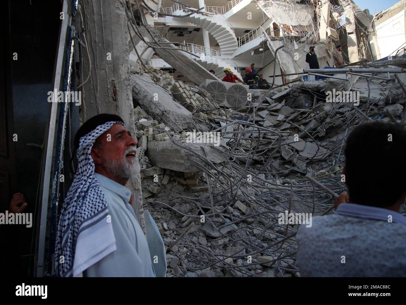 Iraqi emergency and rescue personnel search for survivors in the rubble ...