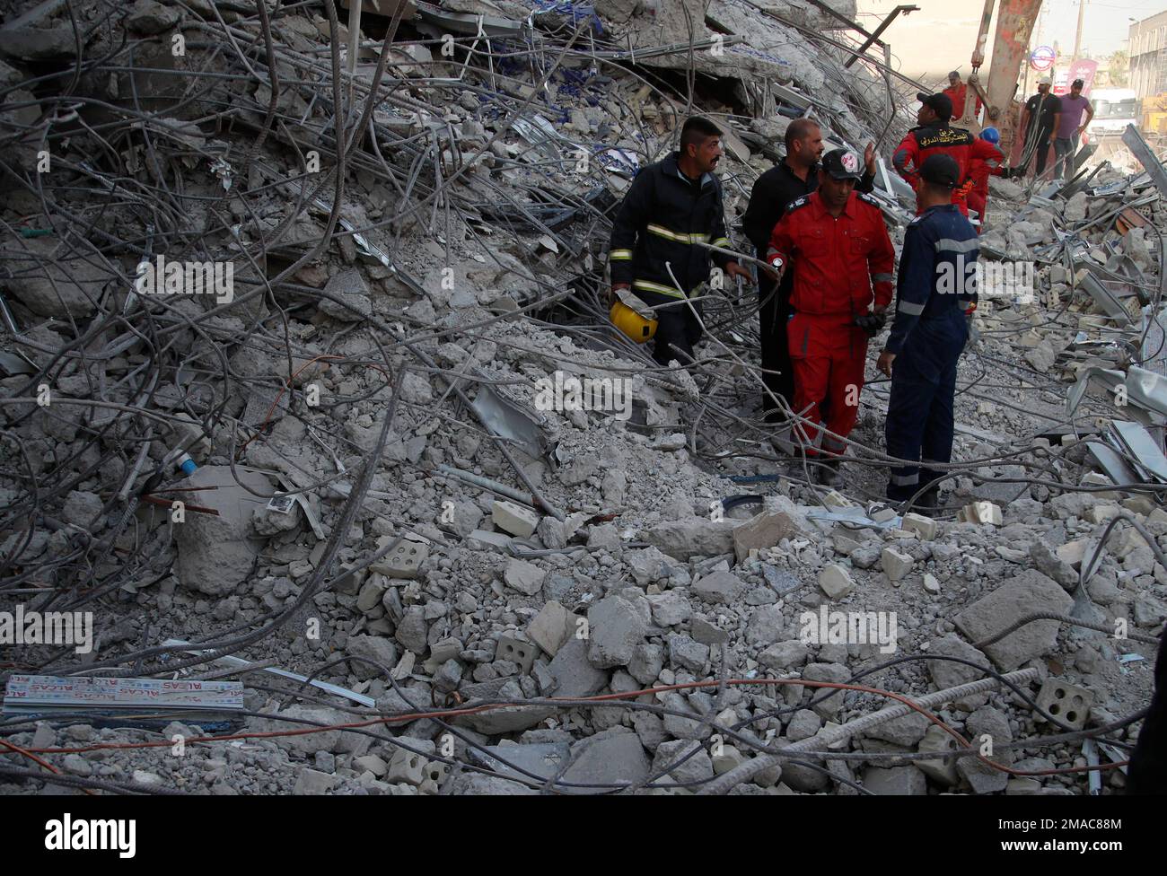 Iraqi emergency and rescue personnel search for survivors in the rubble ...