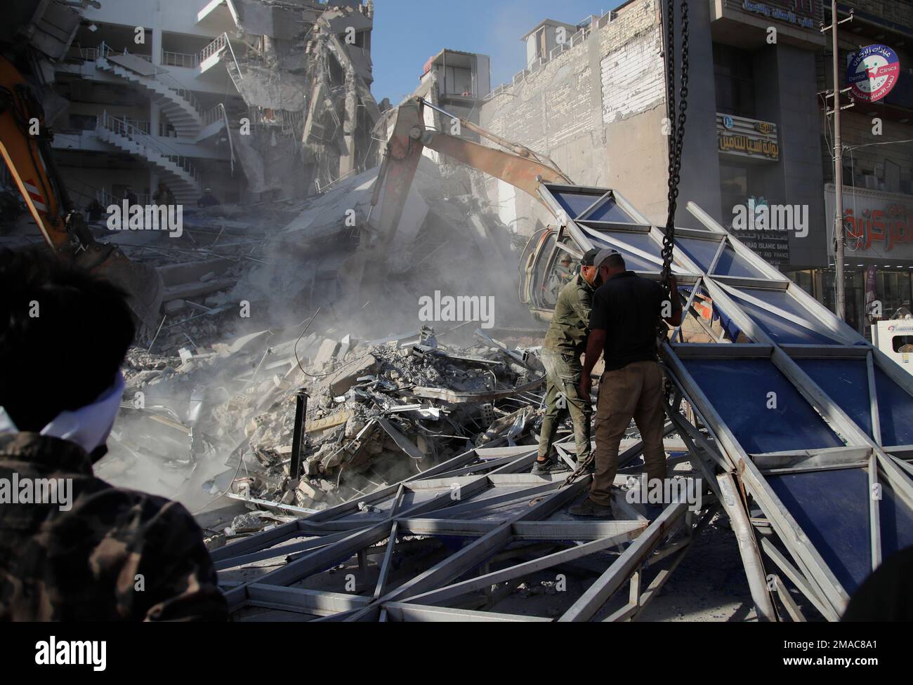 Iraqi emergency and rescue personnel search for survivors in the rubble ...