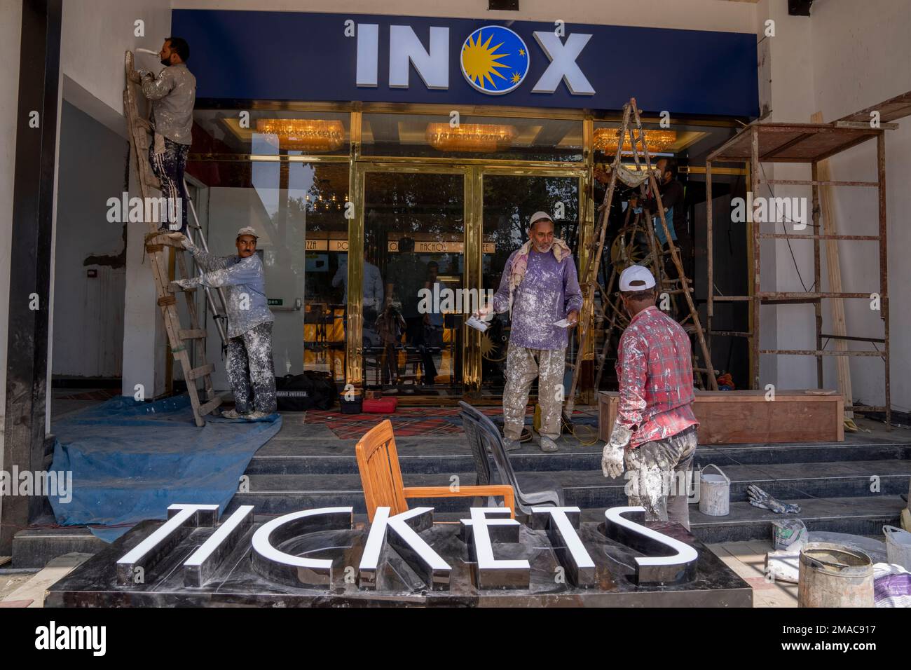 Laborers work outside the newly constructed 'INOX' multiplex in ...