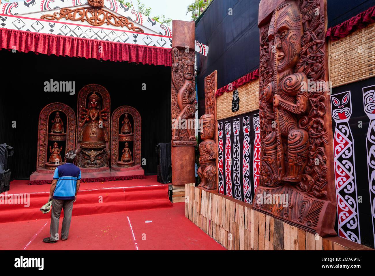 A devotee stand in front of a clay idol of Goddess Durga at a makeshift ...