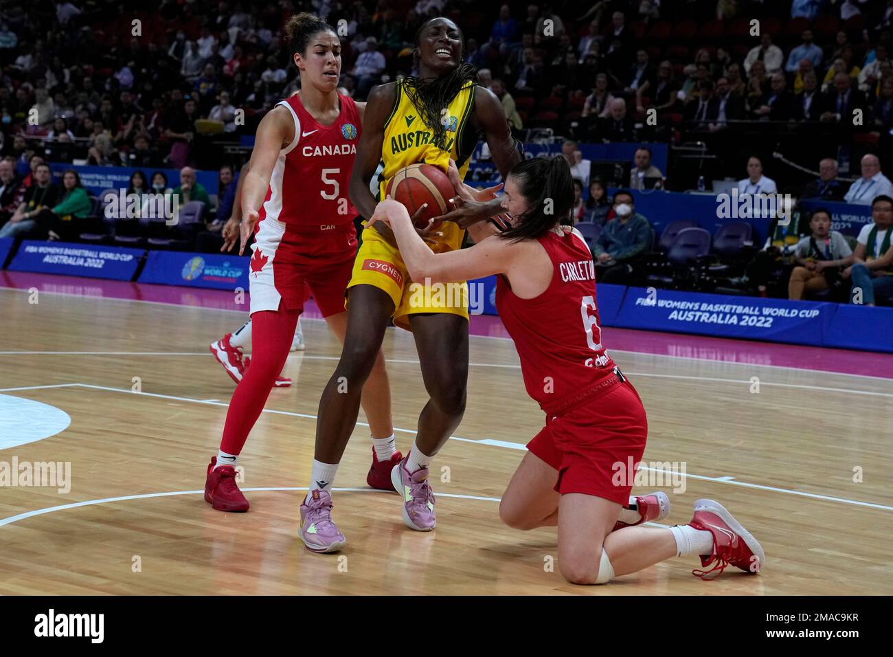 Australia's Ezi Magbegor, center, battles a kneeling Canada's Bridget ...