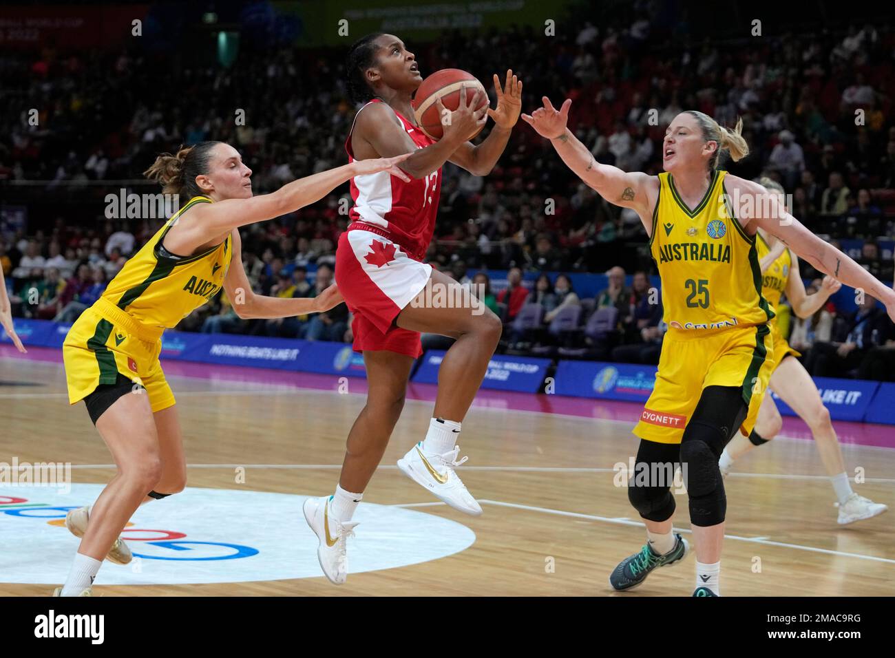 Canada's Shay Colley, center, lays up over Australia's Lauren Jackson ...