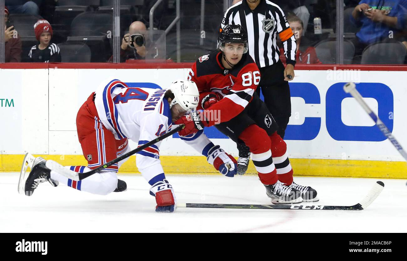 New Jersey Devils center Jack Hughes (86) plays the puck against New ...