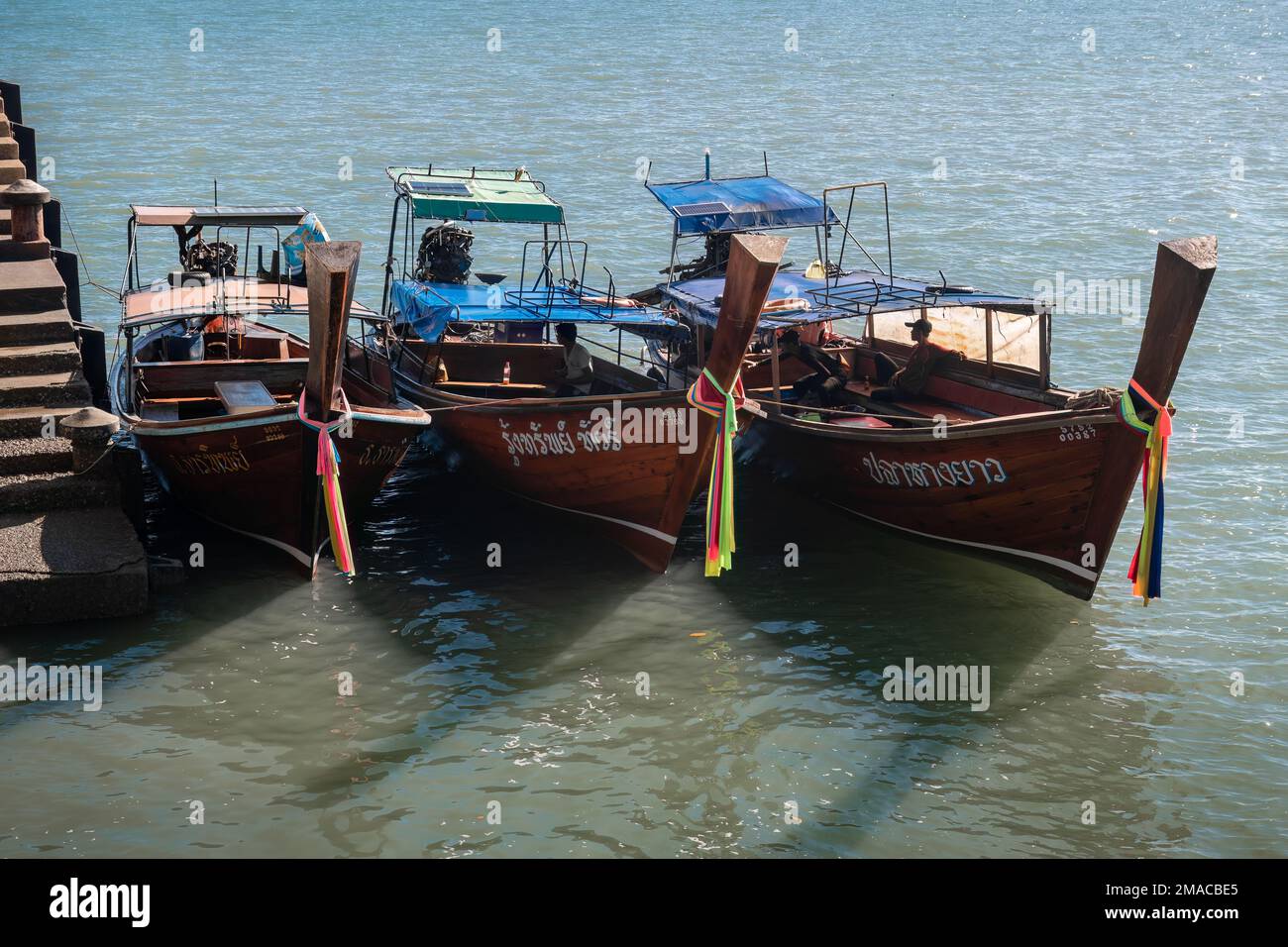 Three long-tail boats docked at the Koh Lanta Old Town Pier in Ko Lanta ...