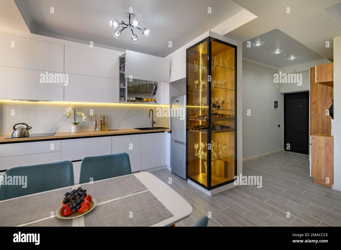 A sleek white studio apartment with a fully functional kitchen Stock ...