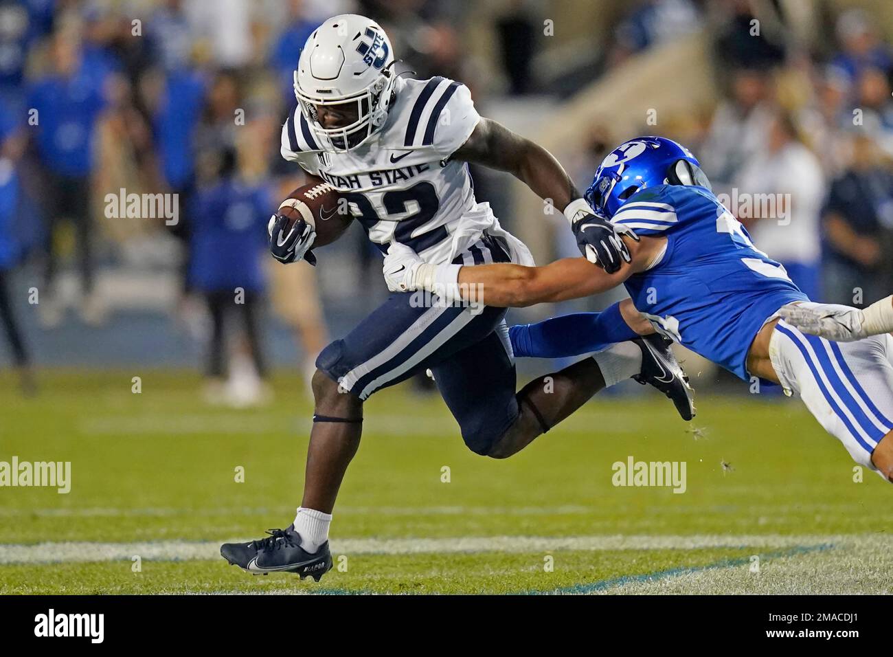 BYU linebacker Max Tooley, right, reaches for Utah State running back ...