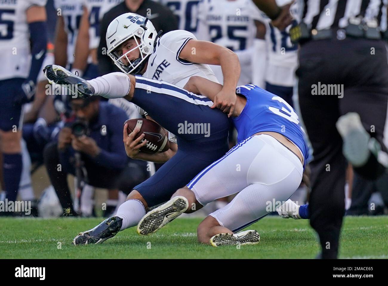BYU linebacker Max Tooley, right, tackles Utah State quarterback Cooper ...
